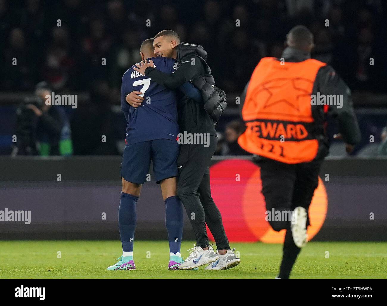 A supporter runs onto the pitch to hug PSG's Kylian Mbappe during the ...