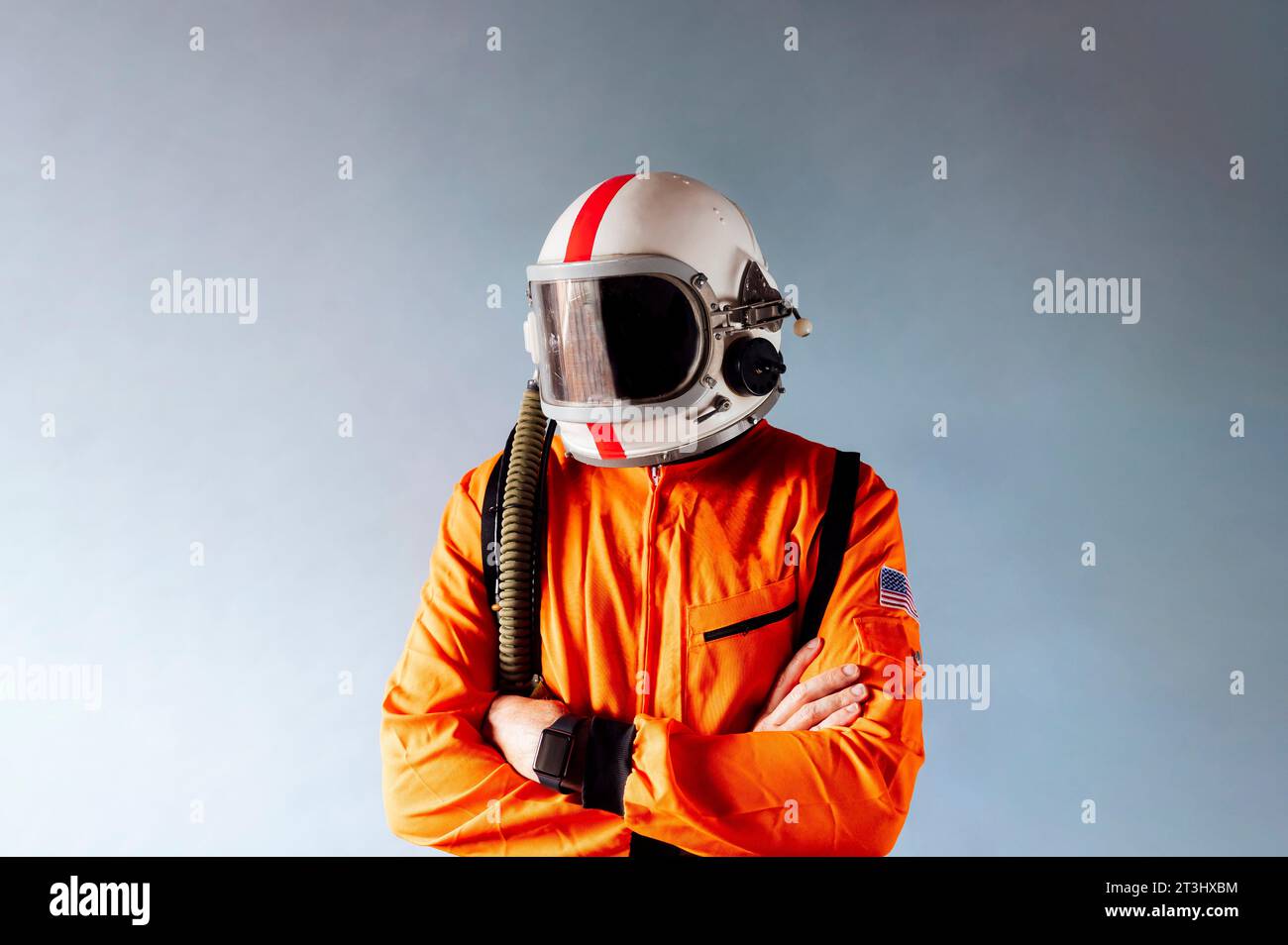 Caucasian man in orange protective suit with arms crossed, looking ...