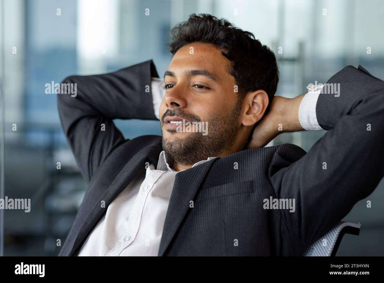 Dreamy thinking man inside office close up smiling and looking out the ...
