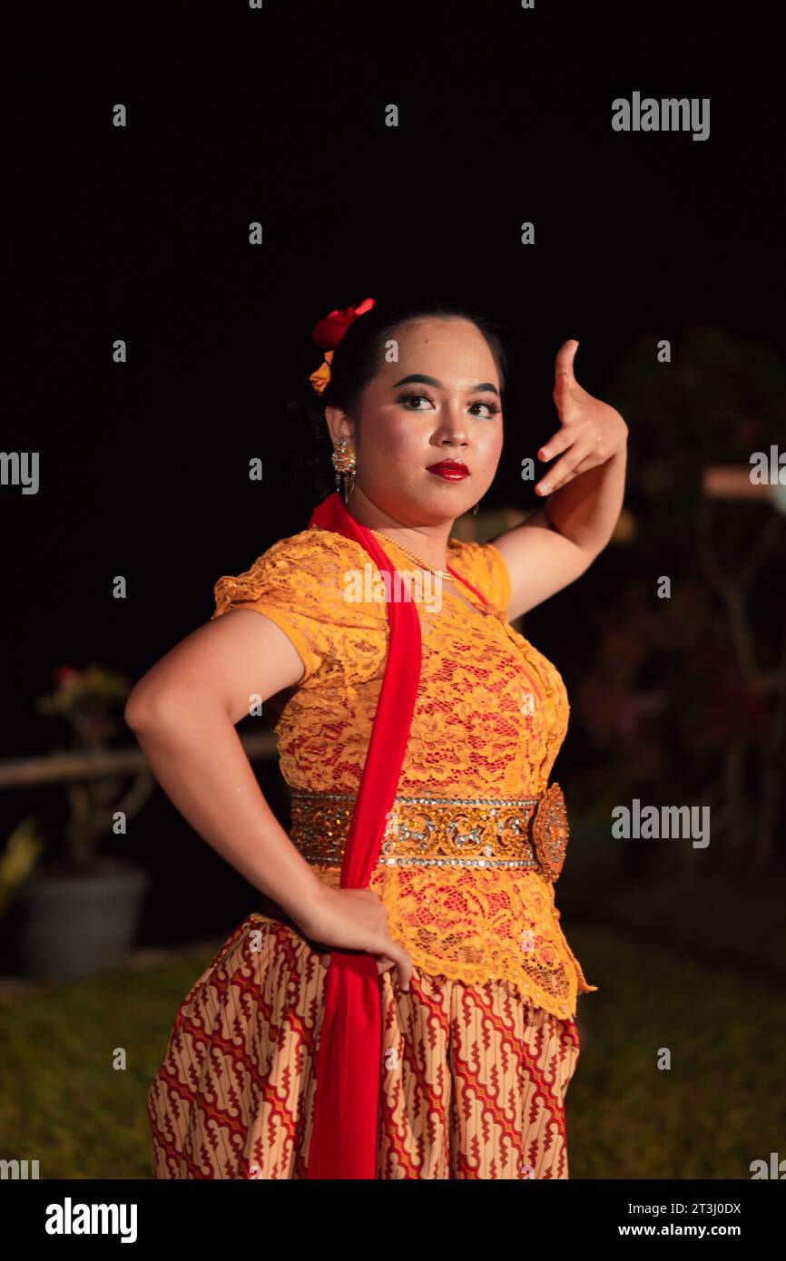 Balinese dancers in yellow color traditional costumes present the dance ...