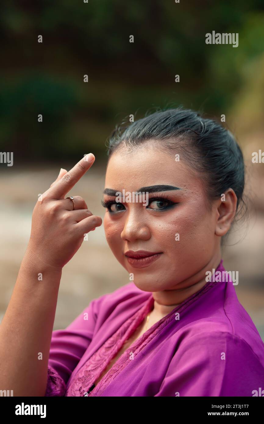 Beautiful Javanese woman with makeup and purple dress posing with her ...