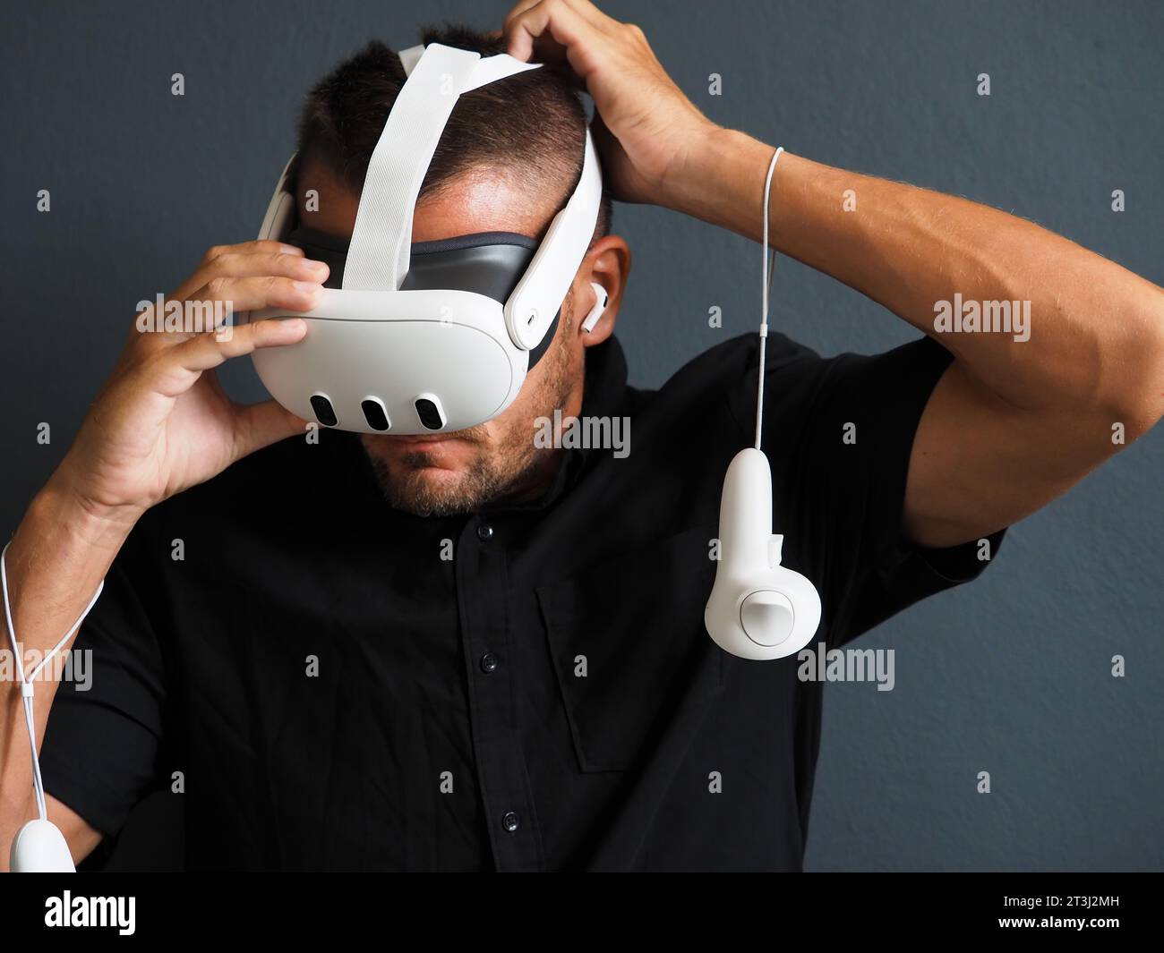 Man puts on mixed virtual reality headset with VR controllers Stock ...