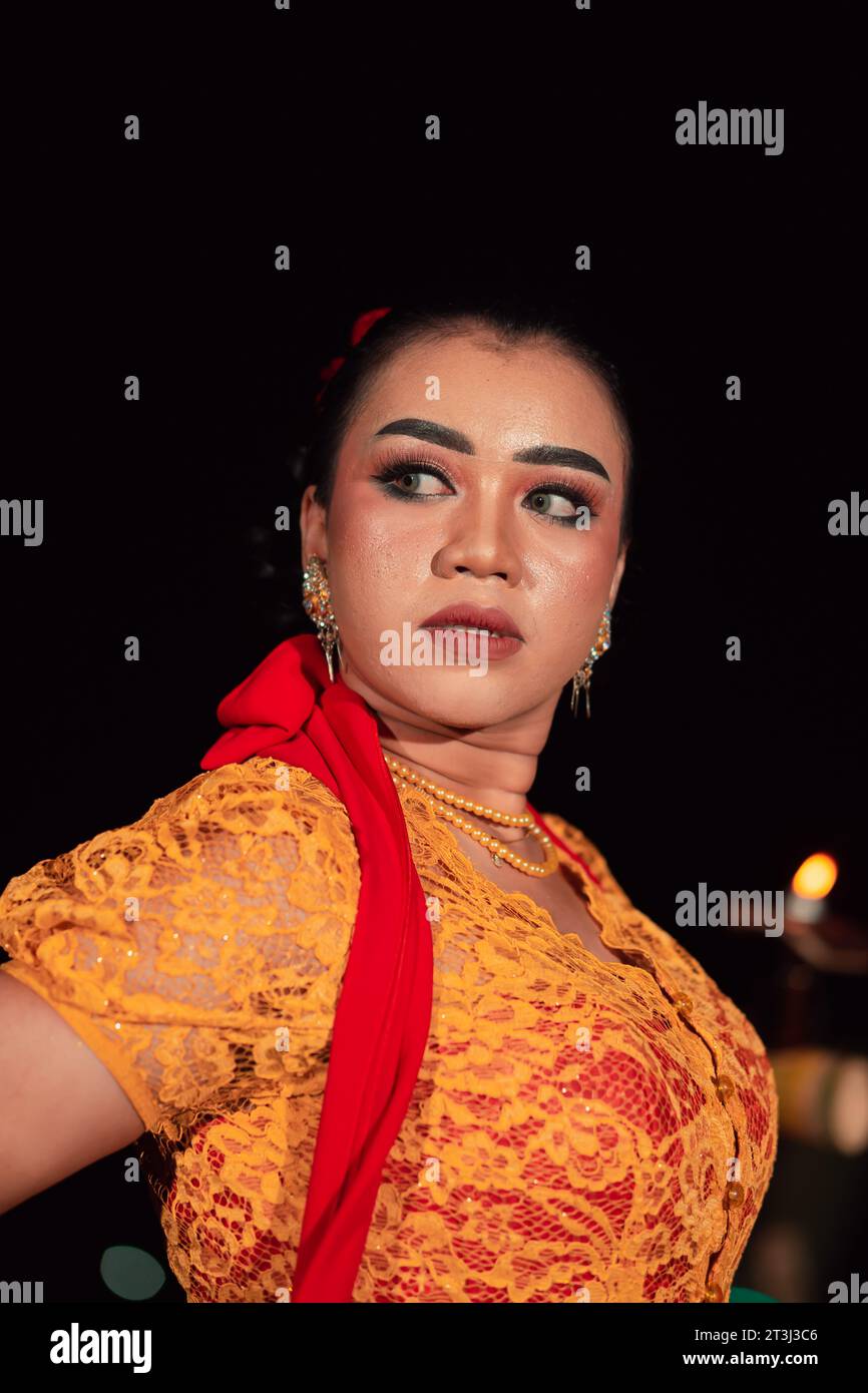 Javanese woman in a traditional orange dress while wearing makeup and a ...