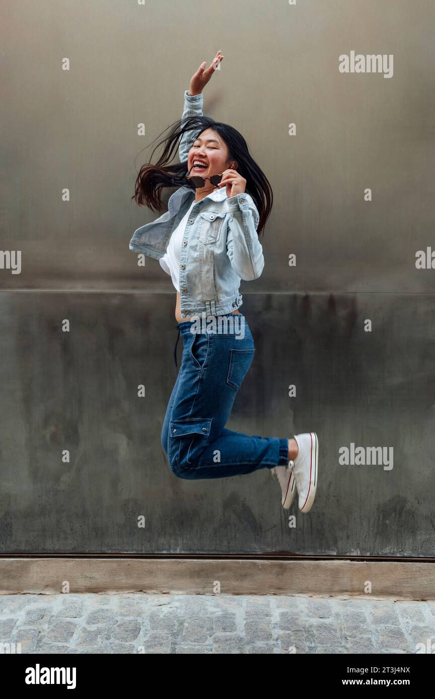 Young woman jumping concrete wall hi-res stock photography and images ...