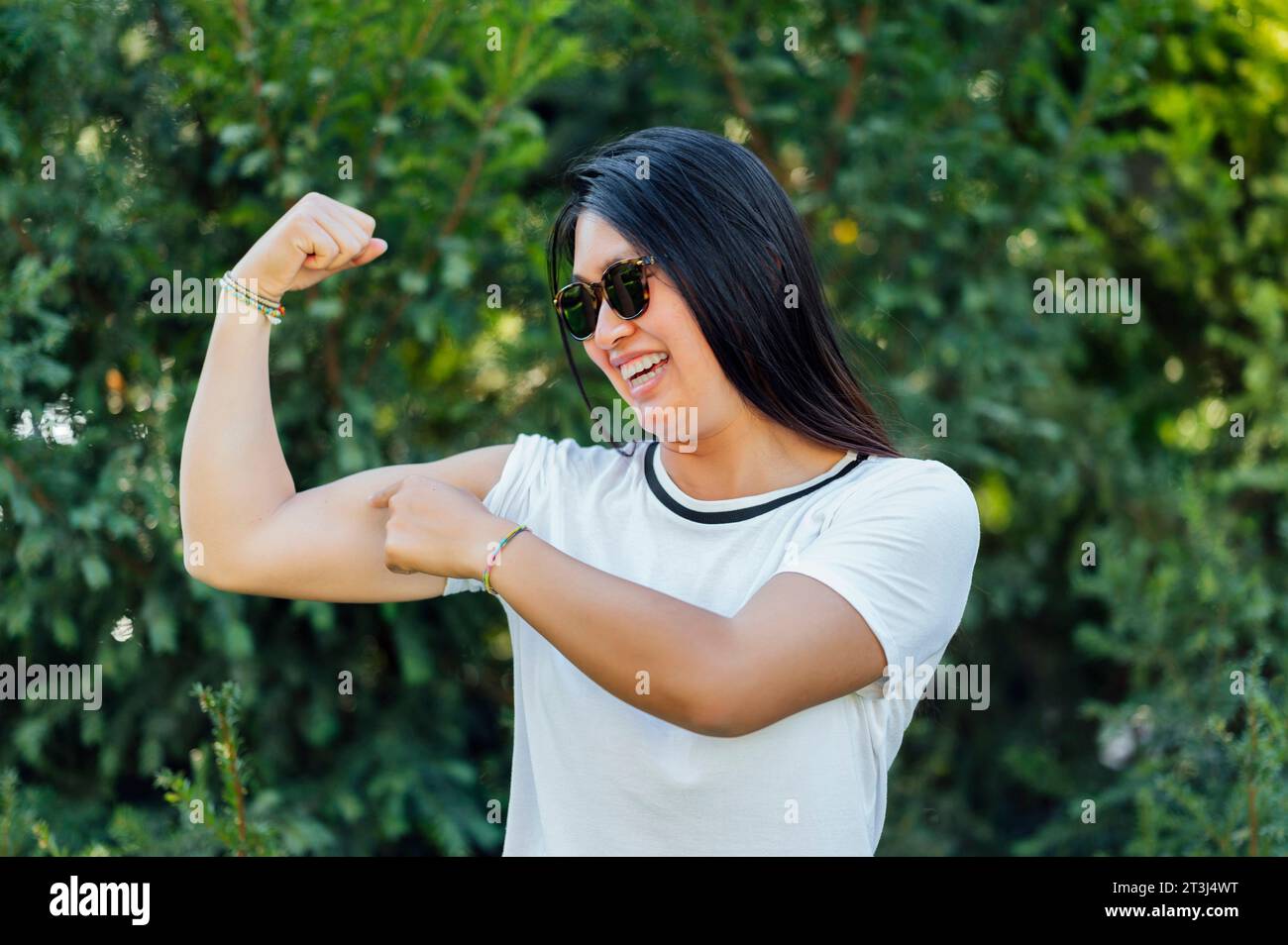 Power woman pointing at arm muscles Stock Photo - Alamy