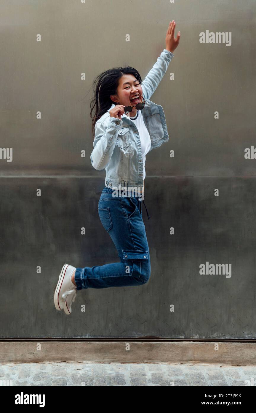 Happy asian woman jumping in the street Stock Photo - Alamy