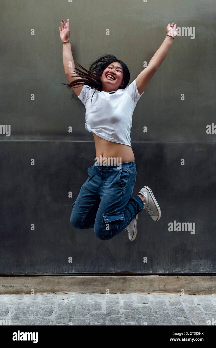 Happy asian woman jumping in the street Stock Photo - Alamy