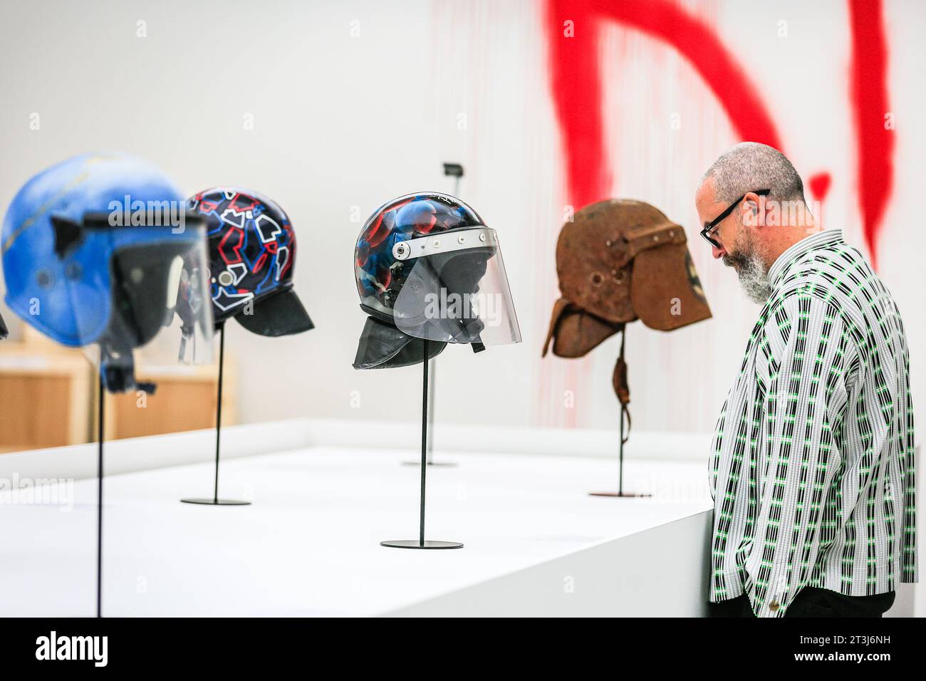 London, UK. 25th Oct, 2023. A visitor looks at several helmets. 'R.I.O ...