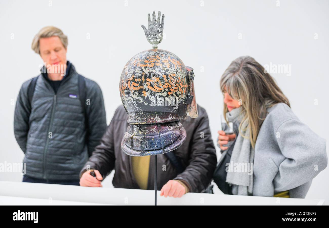 London, UK. 25th Oct, 2023. Visitors look at the helmet created by ...