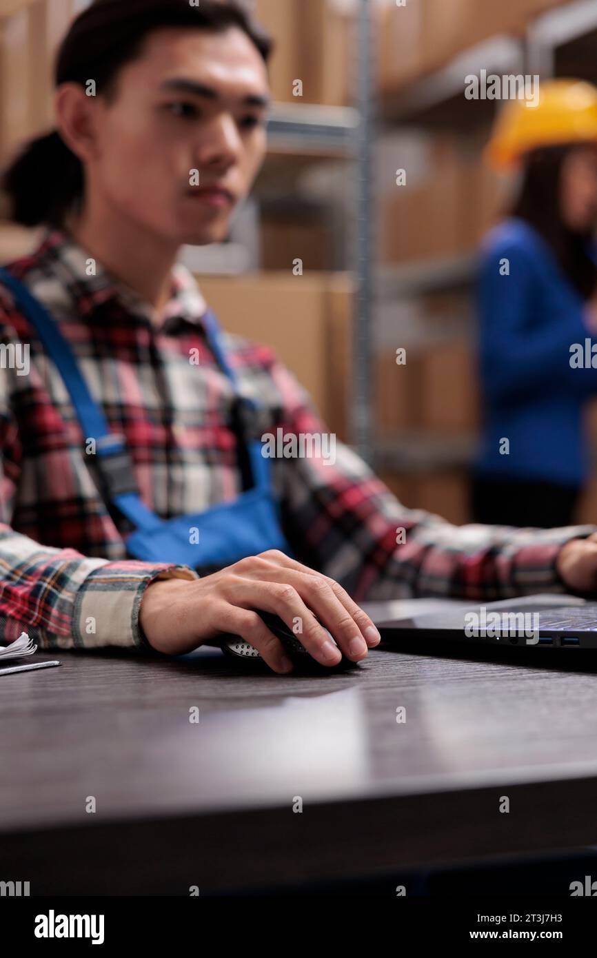 Young asian logistics manager analyzing goods supply on laptop ...