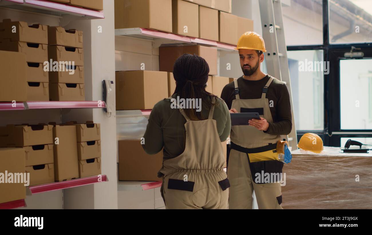 Logistics director and warehouse laborer preparing orders for delivery ...