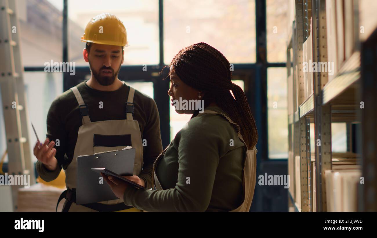 Team leader and worker performing warehouse inventory controls, keeping ...