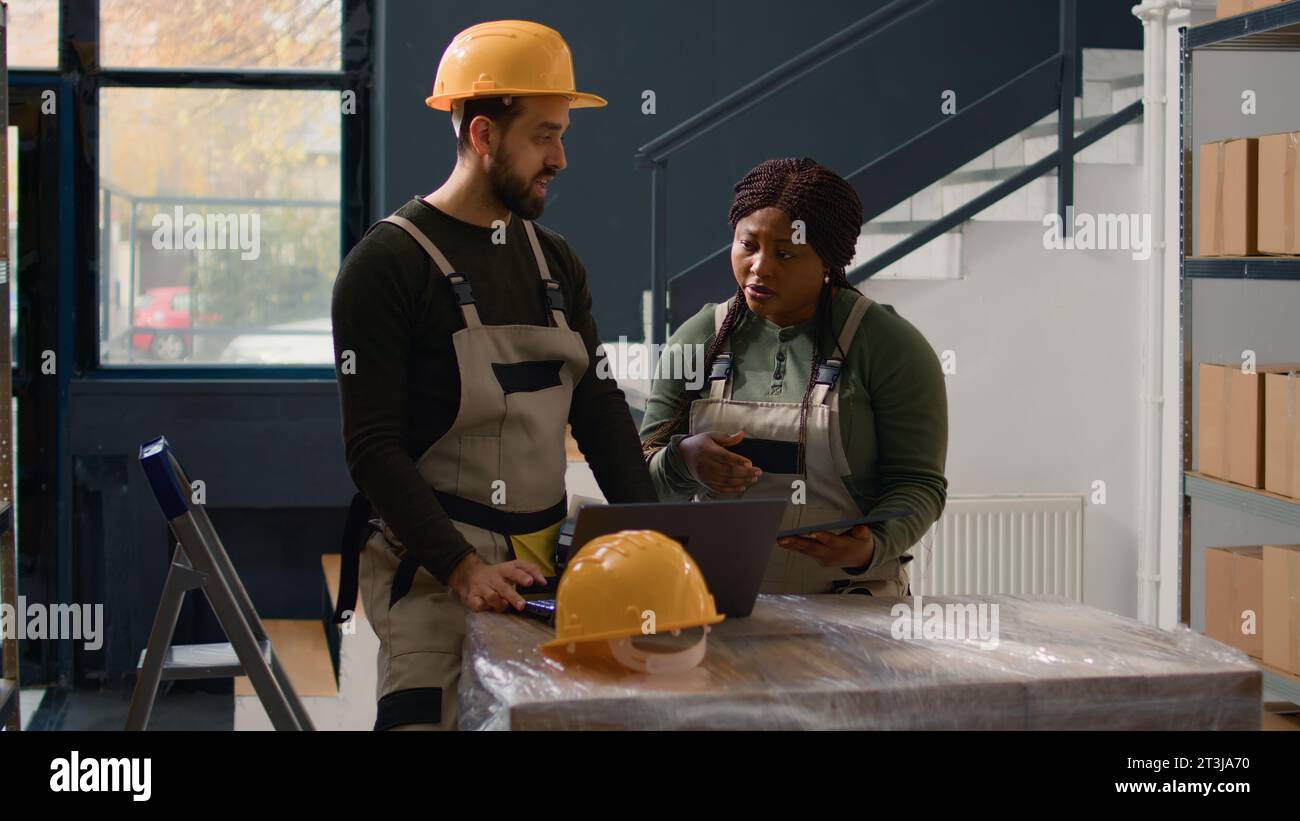 Dolly in shot of employees doing warehouse inventory monitoring ...