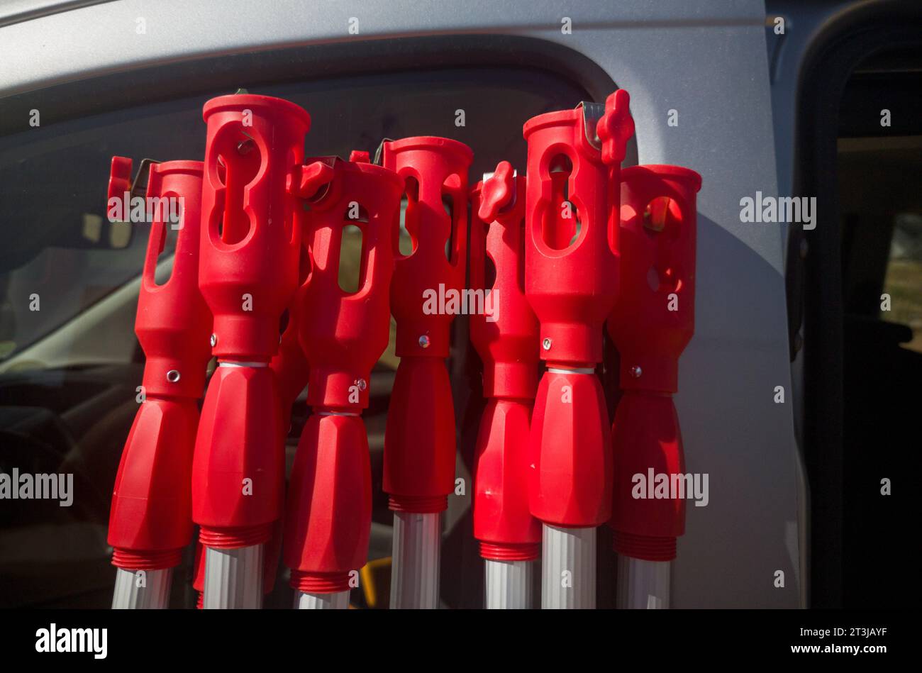 Painting roller extension sticks leaning contractor panel. Red top ...