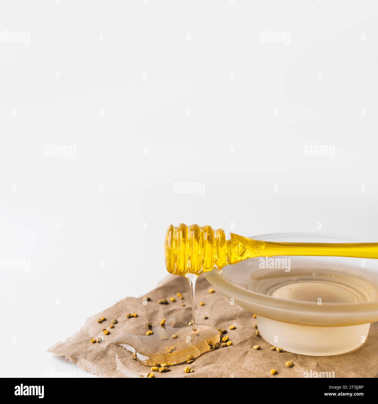 Close up sweet honey dripping from dipper with bee pollen seeds brown ...