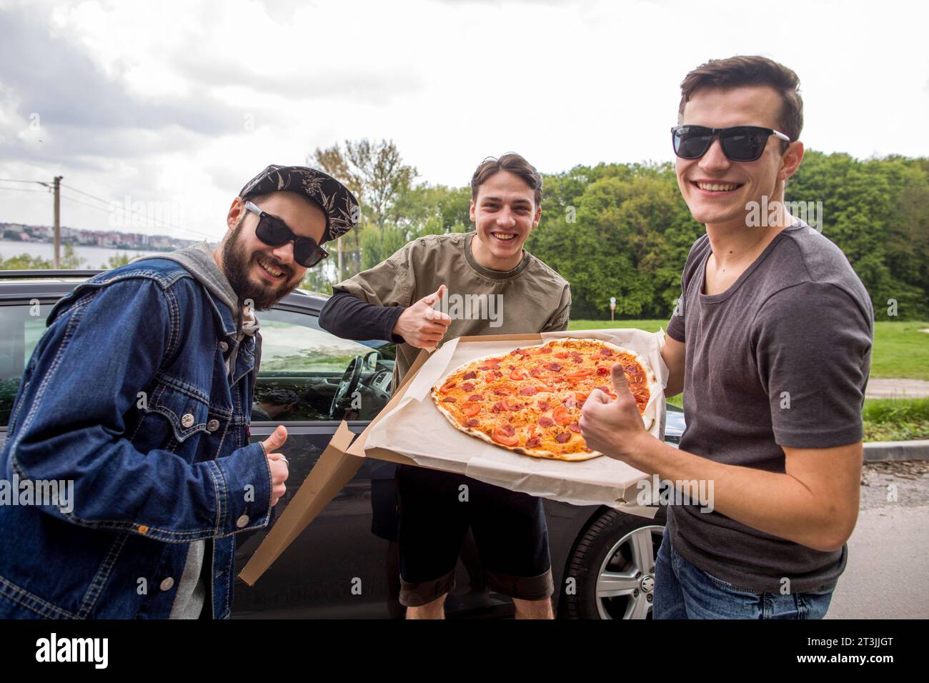 Company young guys with pizza doing excellent sign nature Stock Photo ...