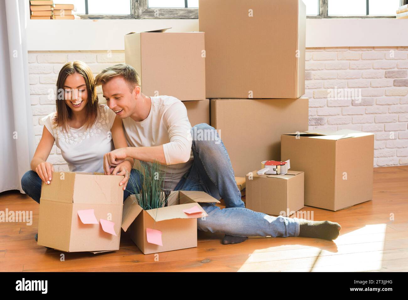 Curious man looking inside cardboard box Stock Photo - Alamy