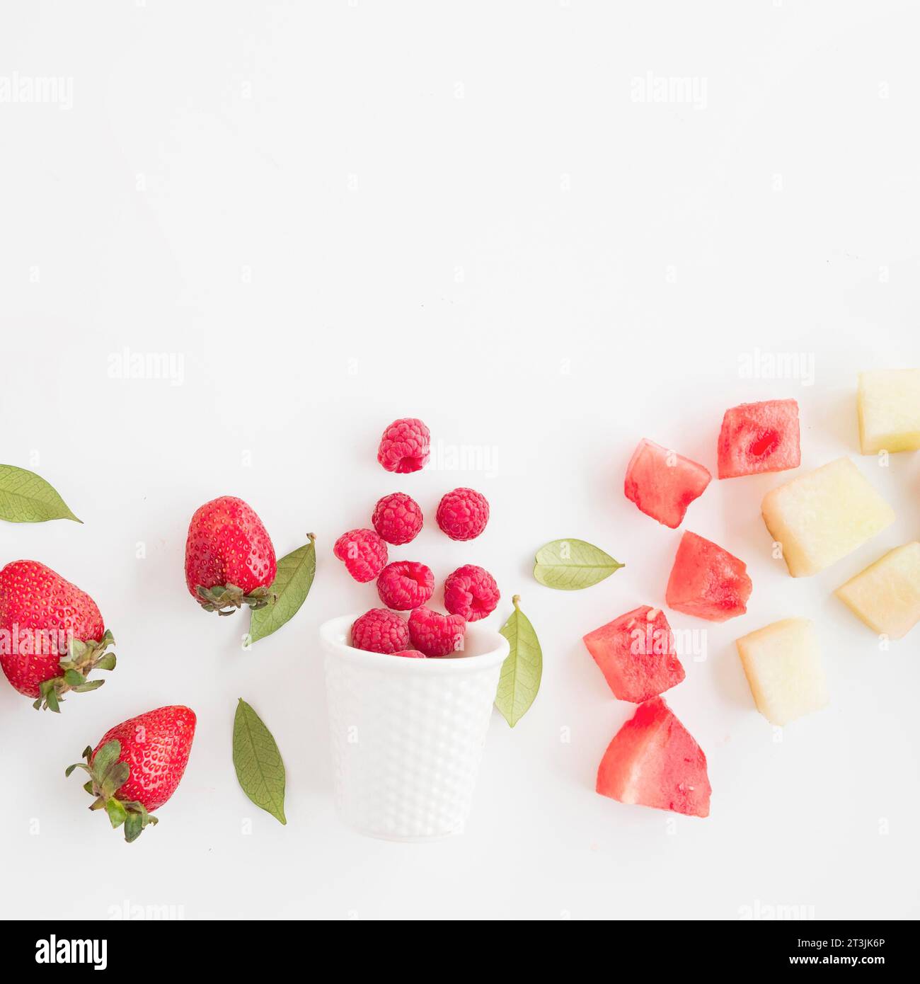 Fresh raspberries spilled front glass with strawberry watermelon ...