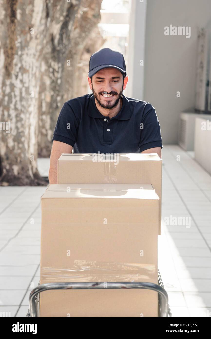 Happy delivery man with cardboard boxes Stock Photo - Alamy