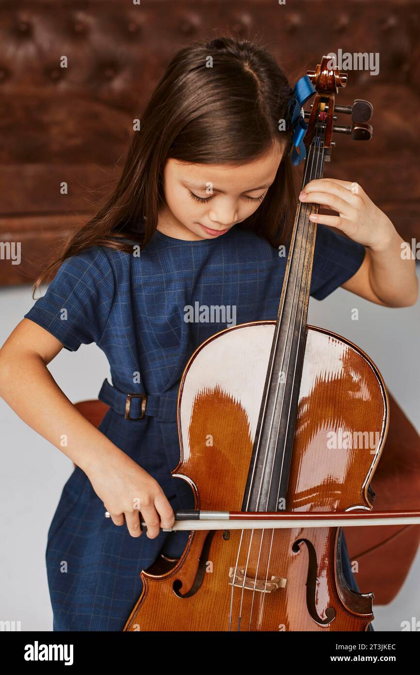 Little cute girl learning how play cello Stock Photo - Alamy