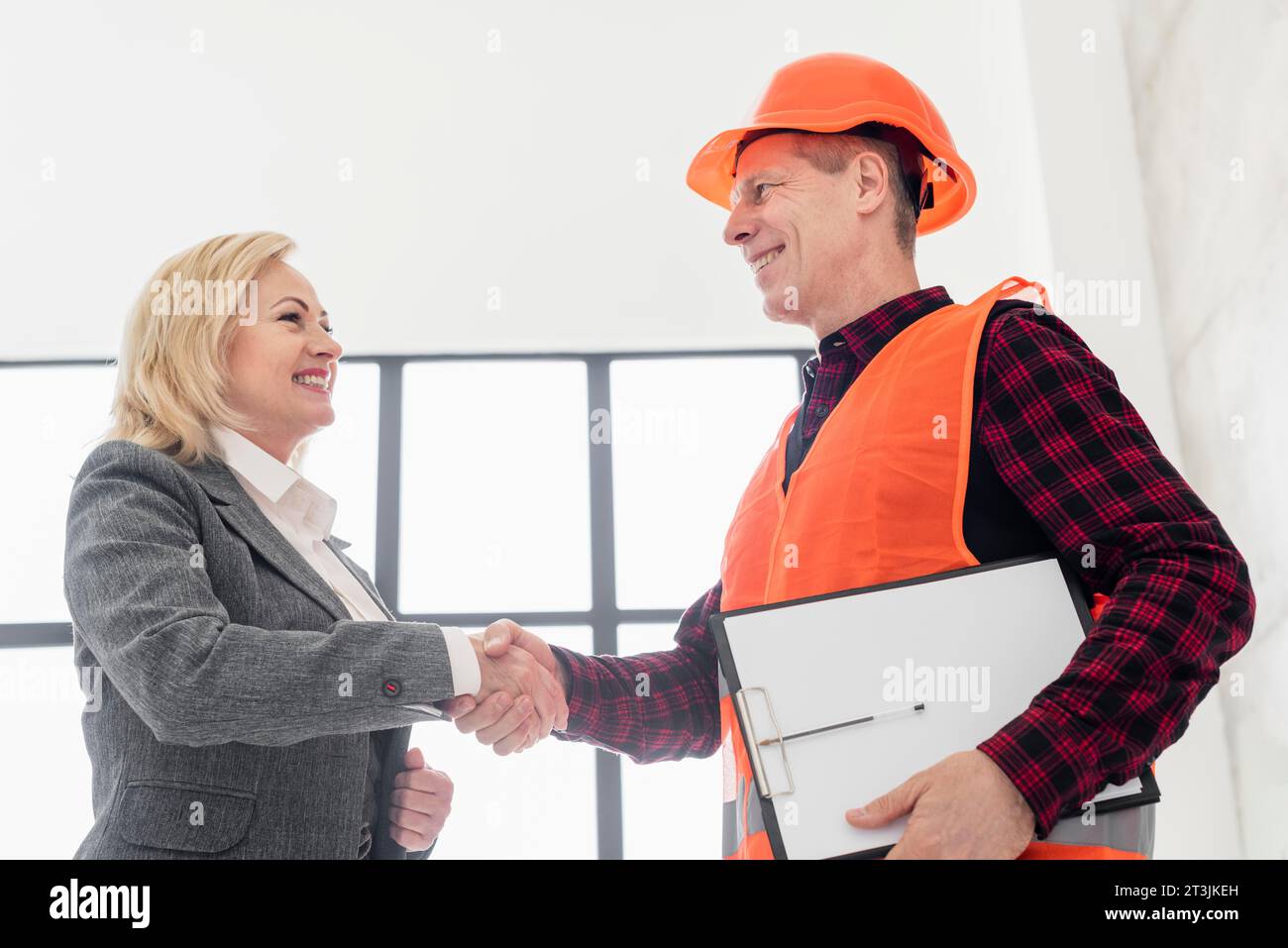 Low angle engineers hand shake Stock Photo - Alamy