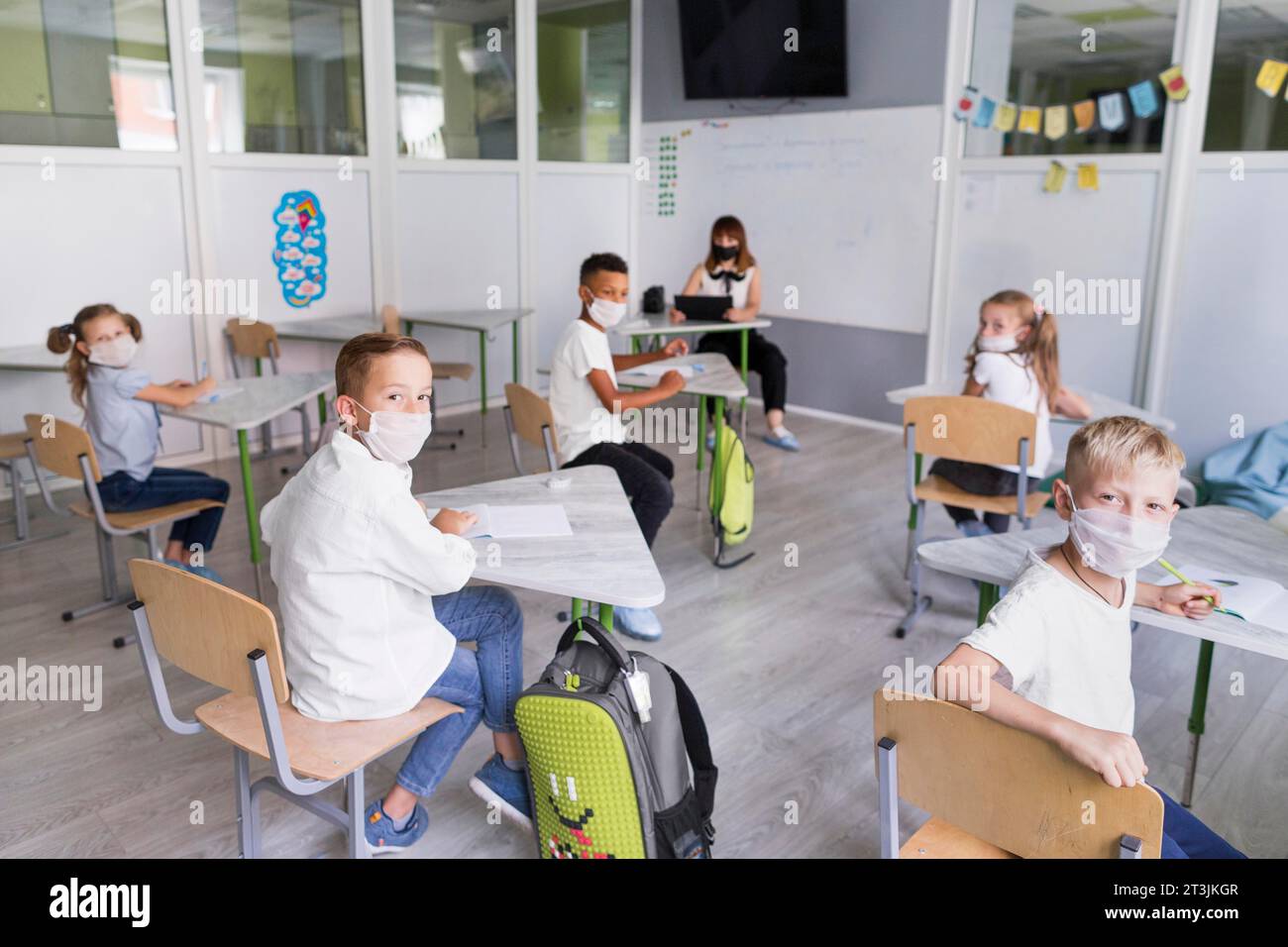 Kids teacher wearing medical masks during pandemic Stock Photo - Alamy
