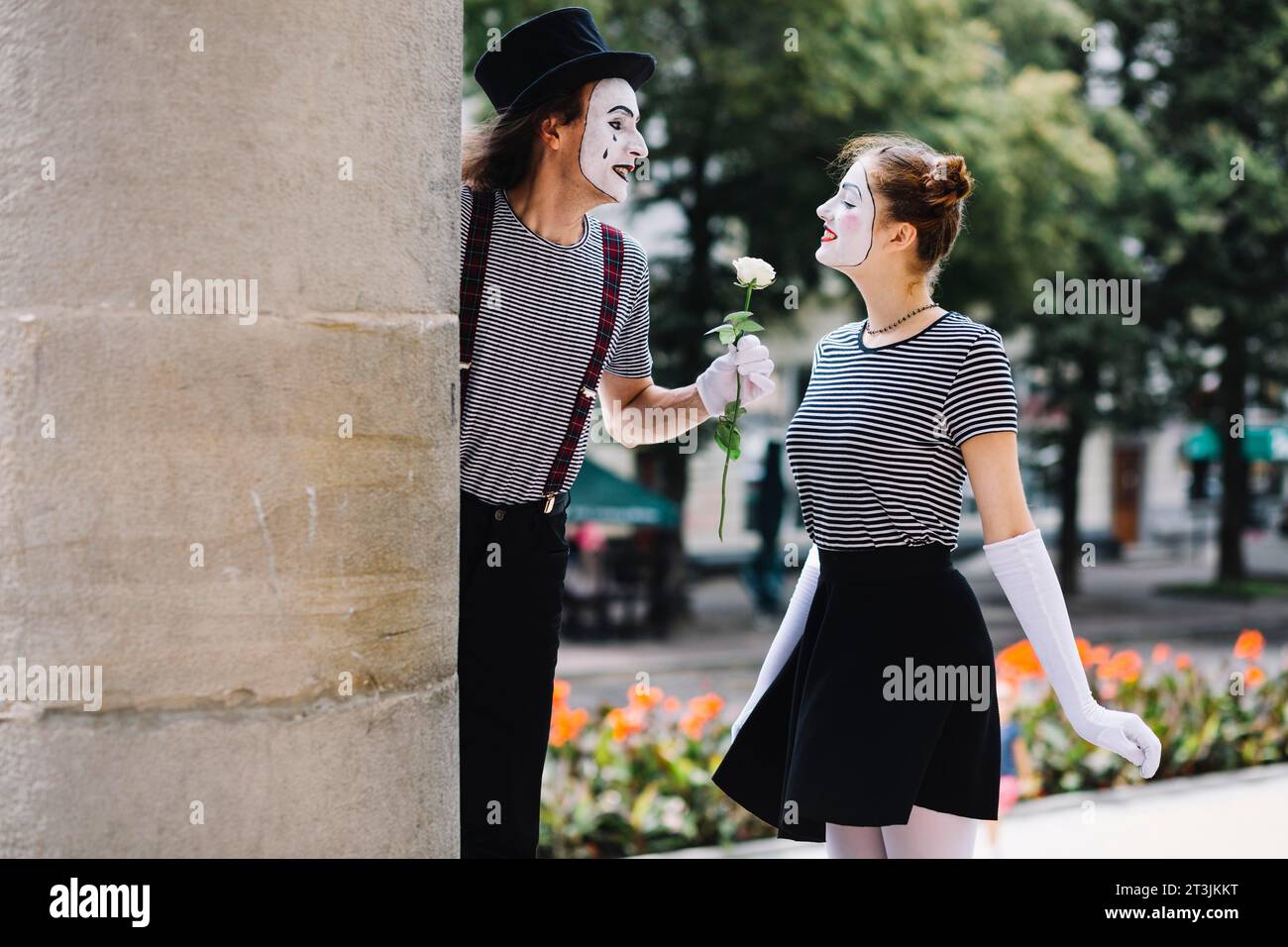 Male mime giving flower female mime Stock Photo - Alamy