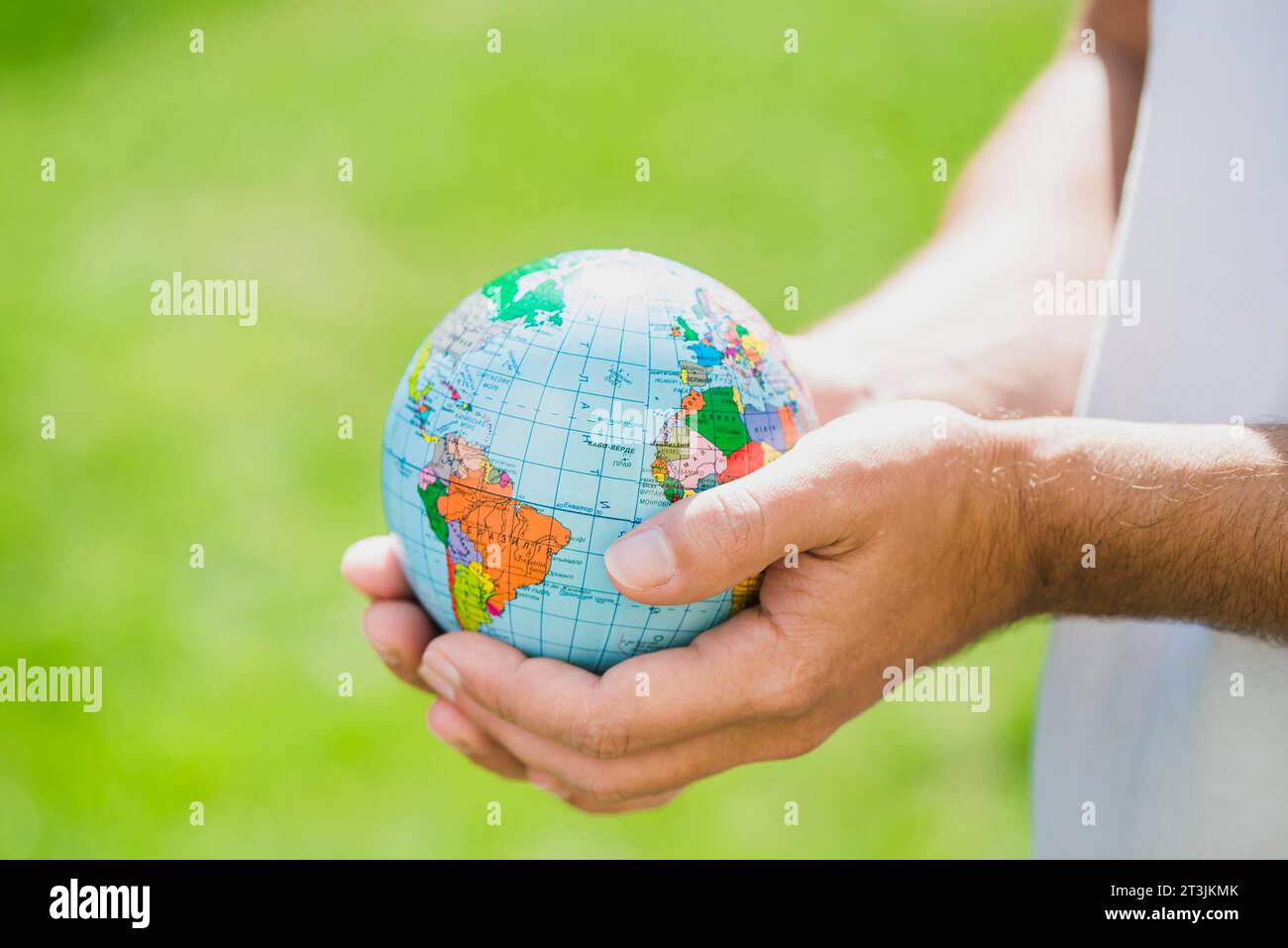 Man s hand holding small globe Stock Photo - Alamy