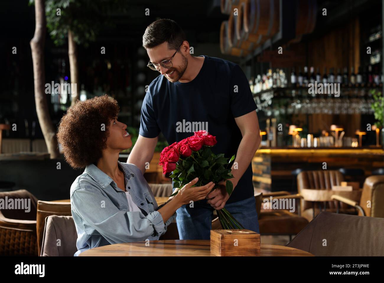 International relationships. Handsome man presenting roses to his ...
