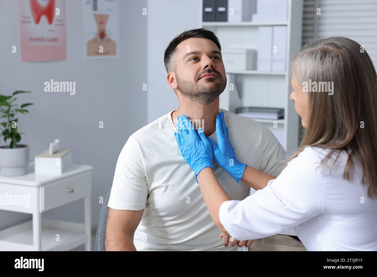 Endocrinologist examining thyroid gland of patient at hospital Stock ...