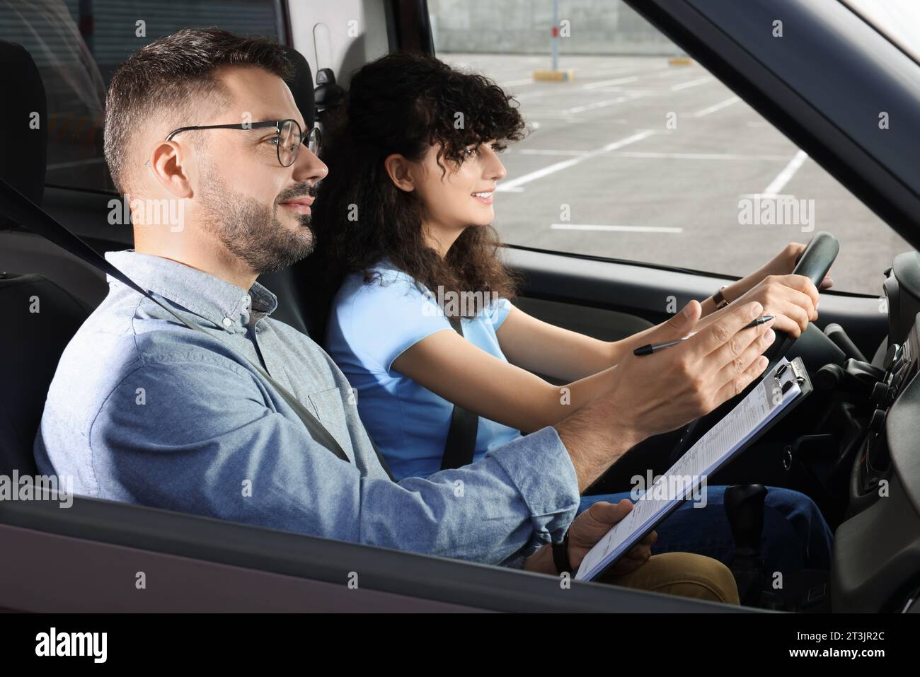 Driving school. Happy student passing driving test with examiner in car ...