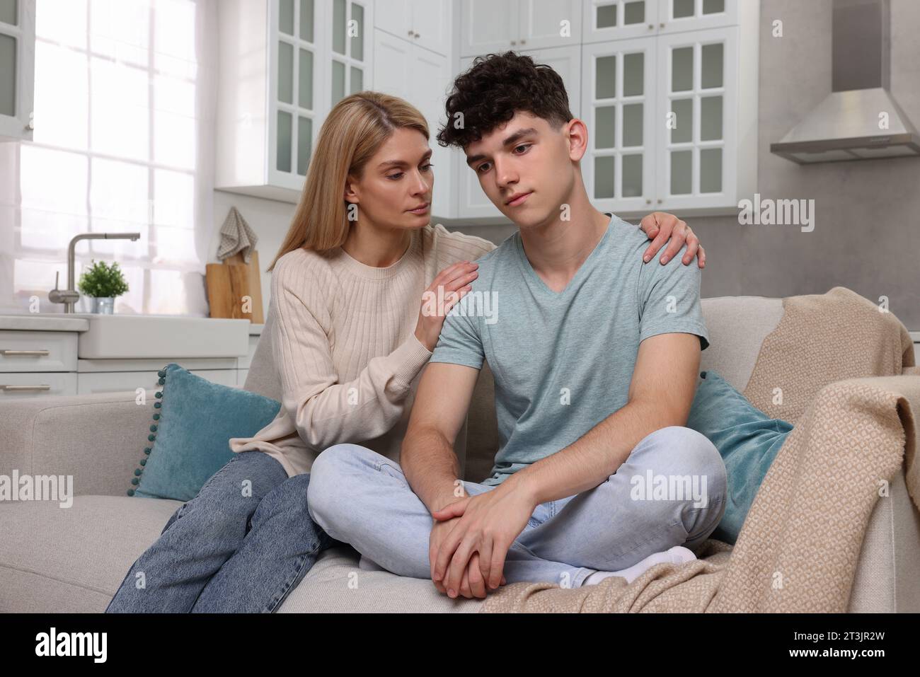 Mother consoling her upset son at home. Teenager problems Stock Photo ...