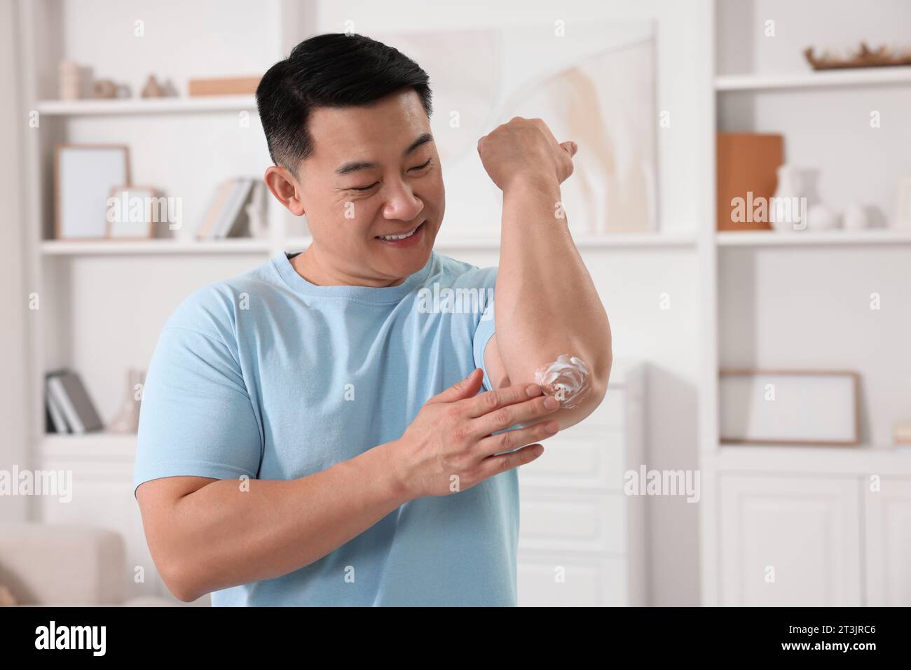 Applying body lotion to her elbow hi-res stock photography and images ...