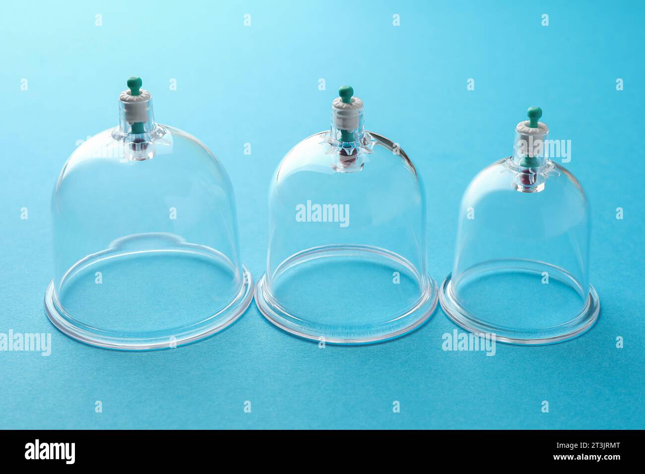 Plastic cups on light blue background. Cupping therapy Stock Photo - Alamy