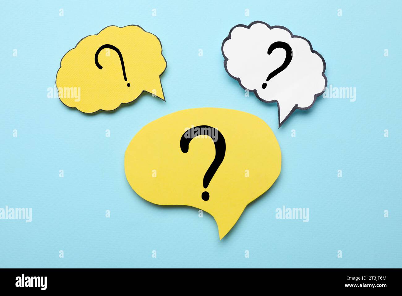 Paper speech bubbles with question marks on light blue background, flat ...