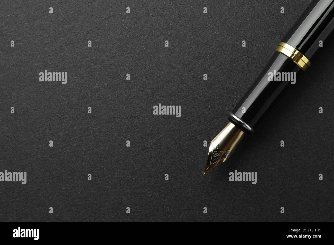 Stylish fountain pen on black background, top view. Space for text ...