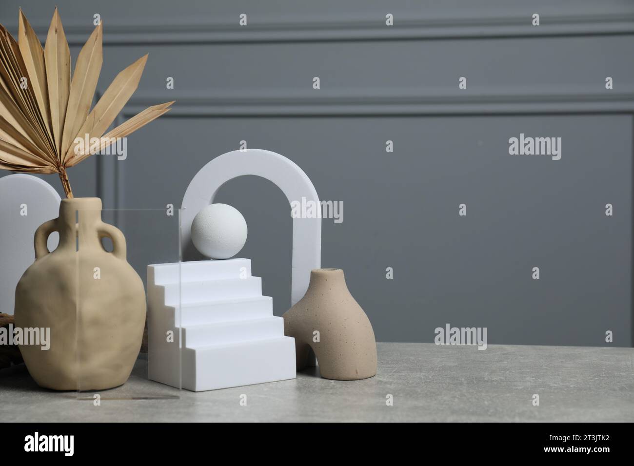 Clay flagon and other decorative elements on grey textured table, space ...