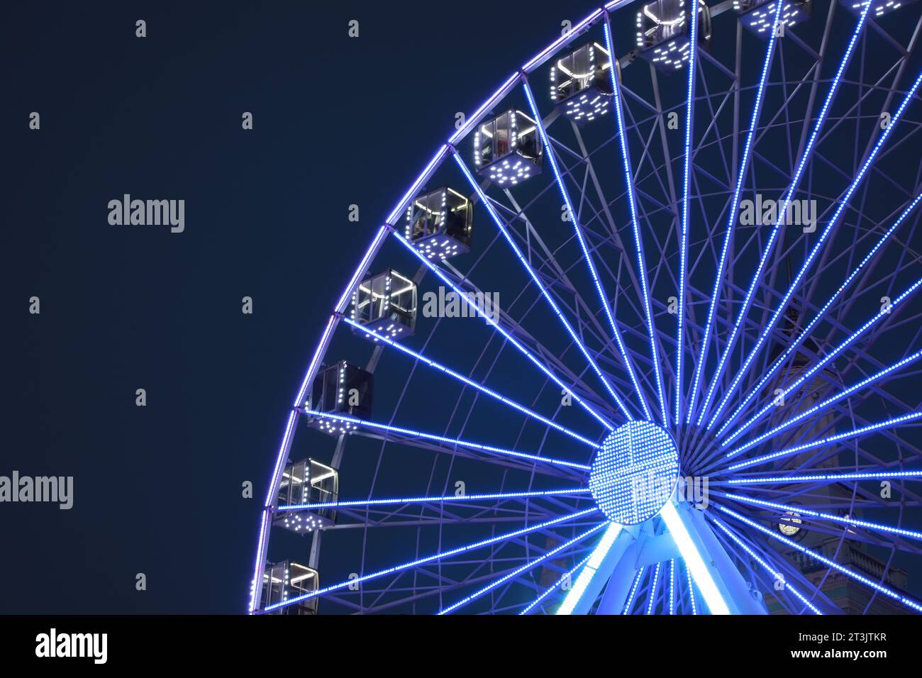 Big glowing Ferris wheel against dark blue sky at night. Space for text ...