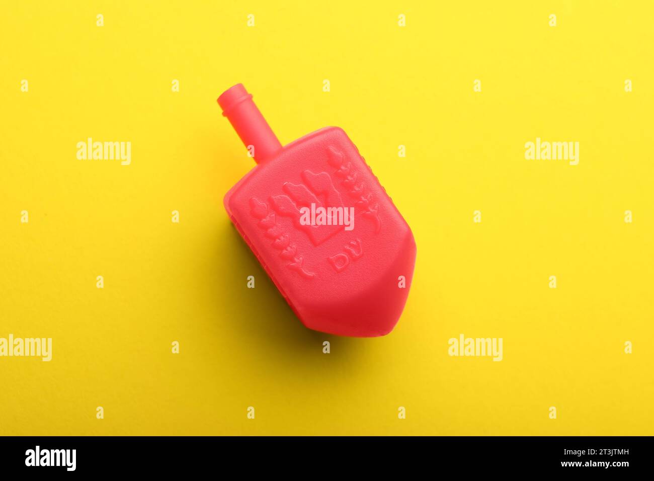 Red dreidel on yellow background, top view. Traditional Hanukkah game ...