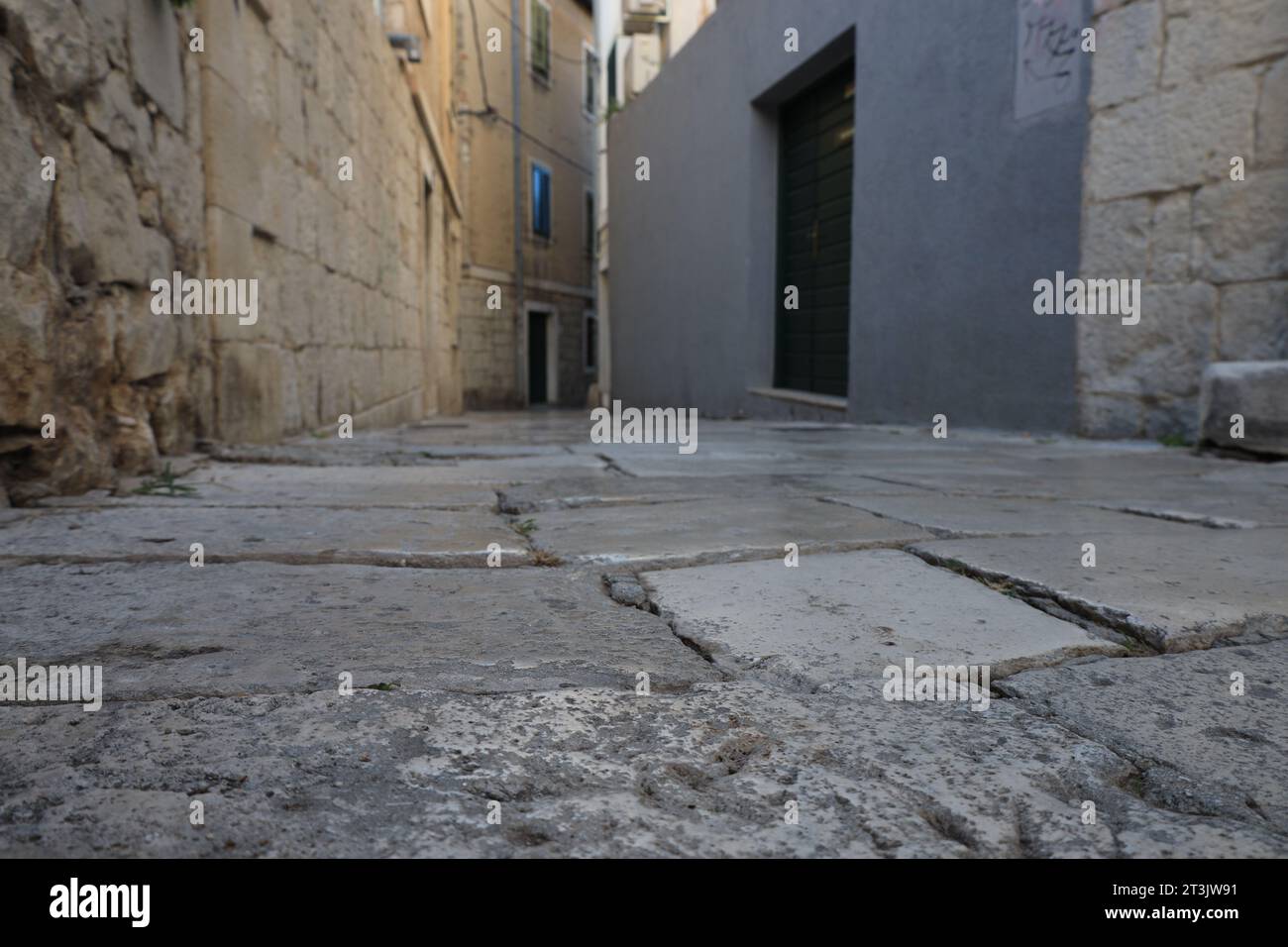 Empty paved alleyway between residential buildings in town Stock Photo ...
