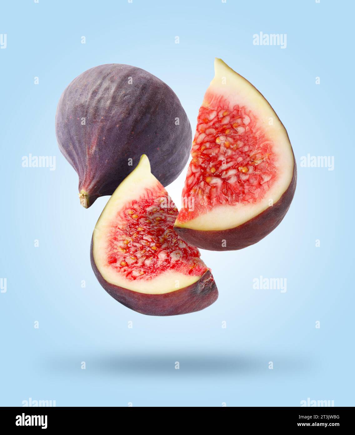 Fresh figs falling on light blue background Stock Photo - Alamy