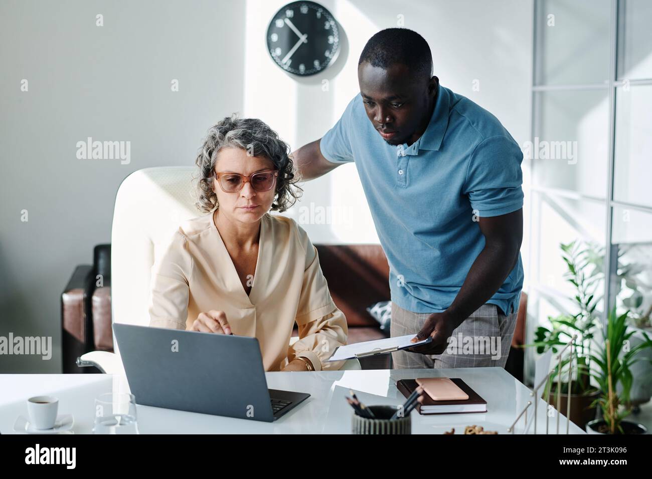 Confident female director of company pointing at laptop screen while ...