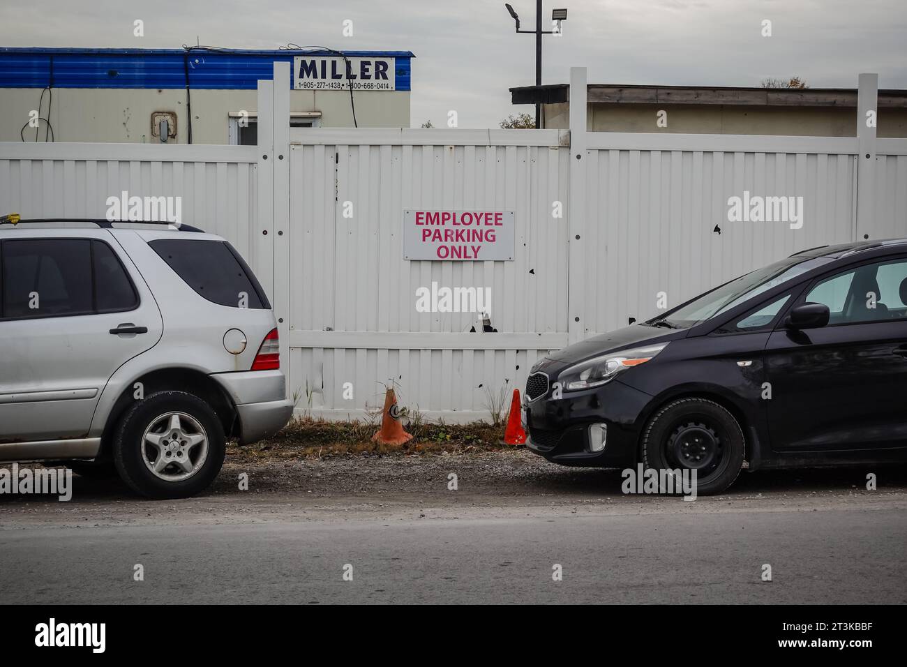 employee parking only sign between two cars on the side of a road Stock ...
