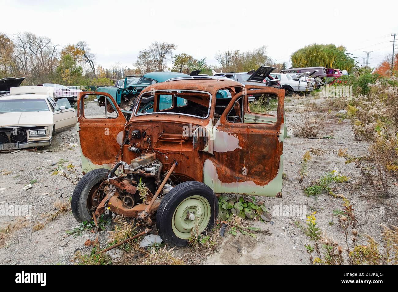 An old rusty car with many parts removed including the front hood and the engine Stock Photo - Alamy