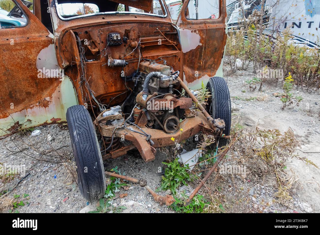 An old rusty car with many parts removed including the front hood and the engine Stock Photo - Alamy
