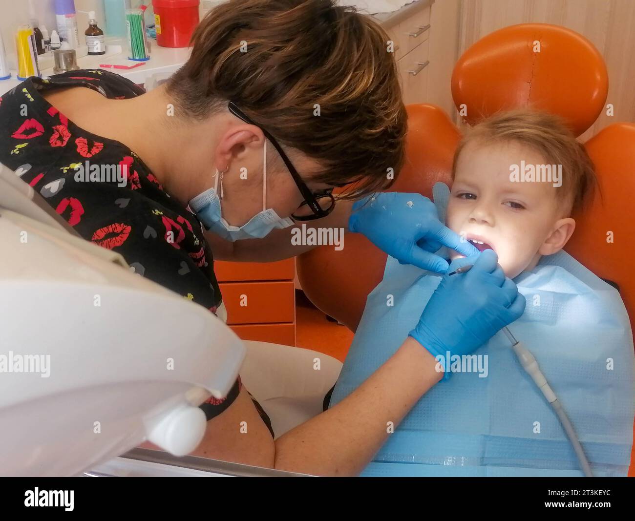 Female dentist examines the teeth of the patient cheerful child with ...