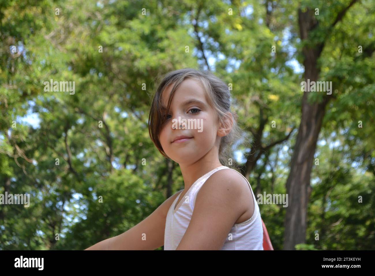 Cute kid girl 10 year old posing on nature background. Looking at ...
