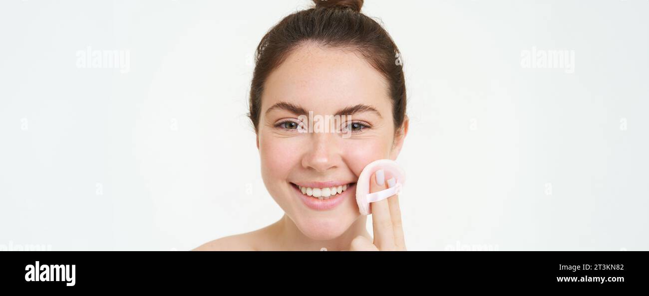 Portrait of smiling happy woman without blemishes, using cosmetic pad ...