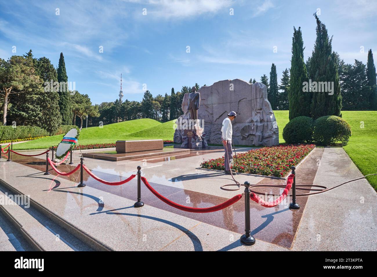 A gardener waters flowers at the grave and statue of former president ...