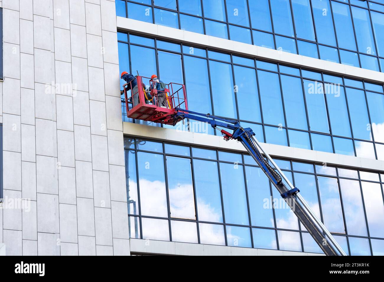 External glass facade window washers, while in a construction lifting ...